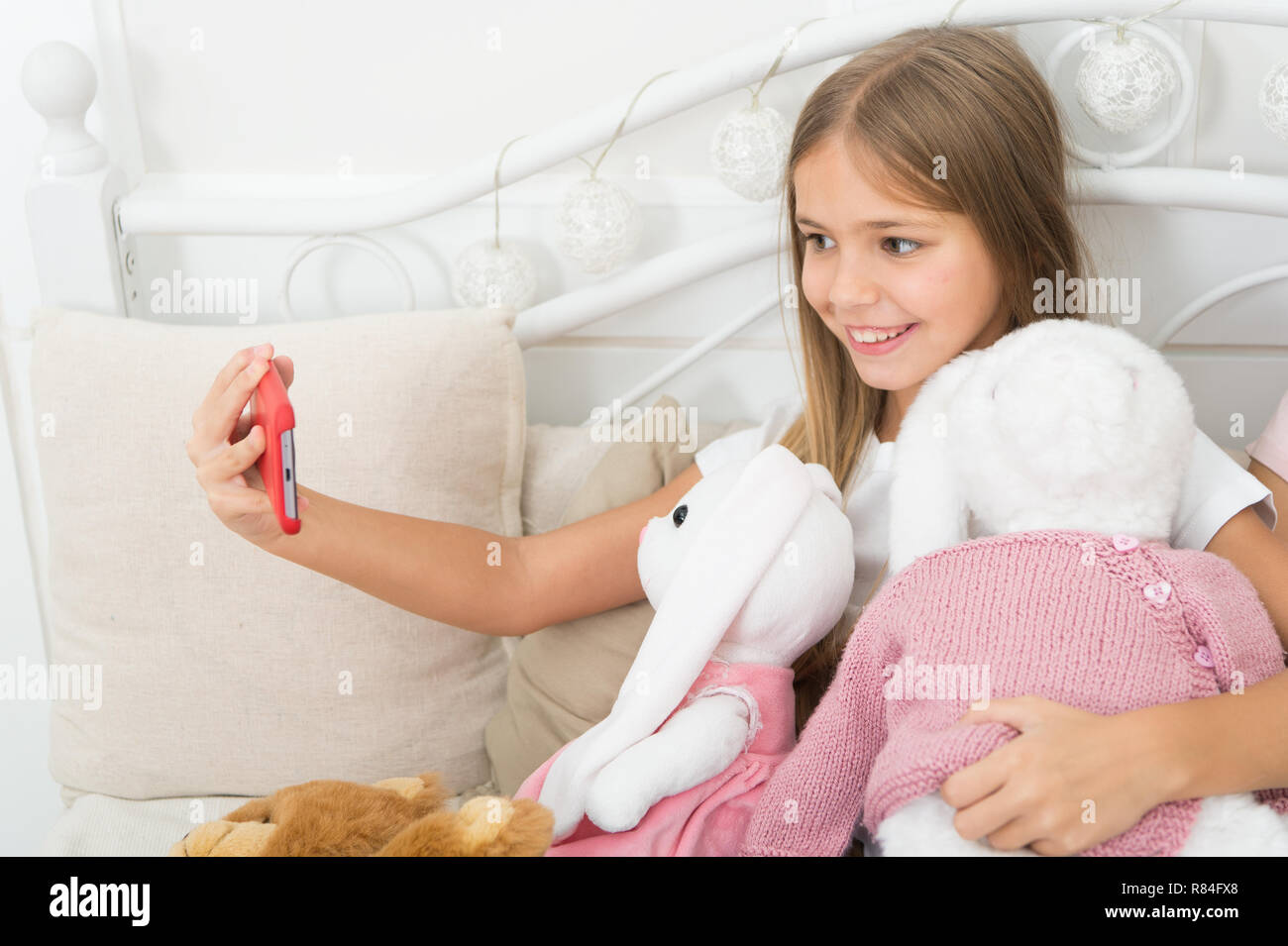 Girl with smartphone use modern technology. Selfie with favorite toy ...