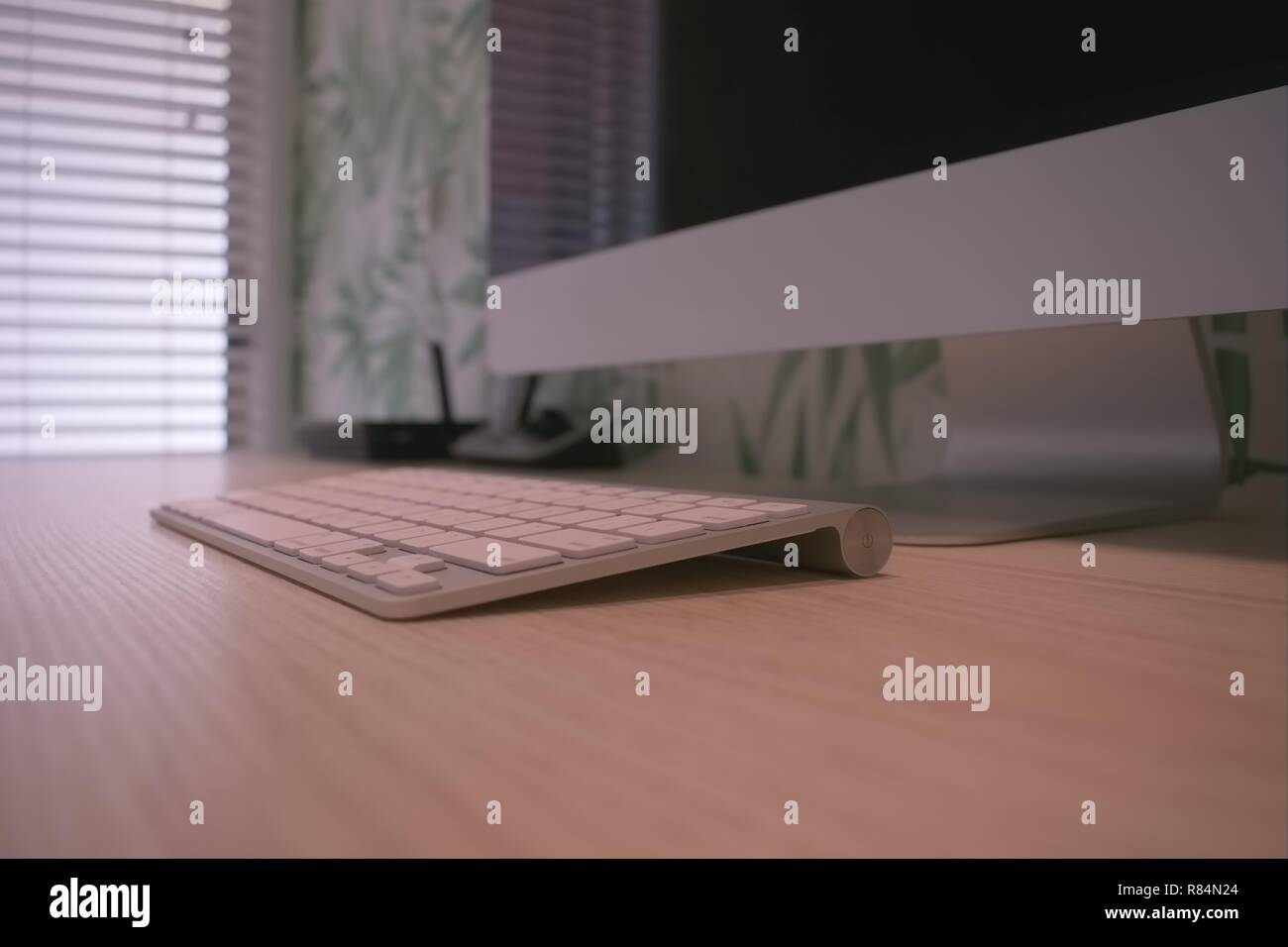 Low angle view of keyboard and computer on a desk in a modern home ...