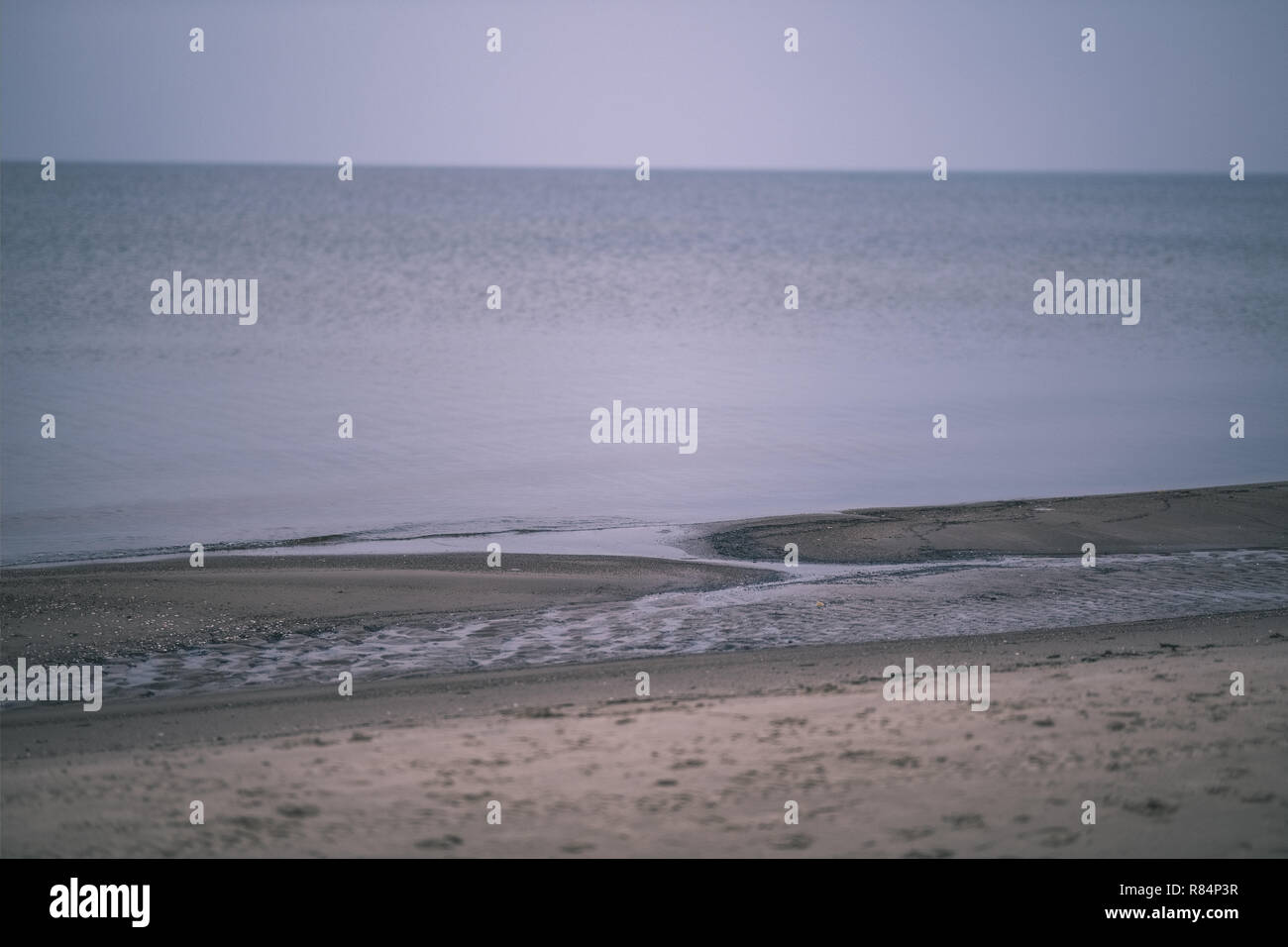 empty sea beach in autumn with mist and cool tones in empty sand ...