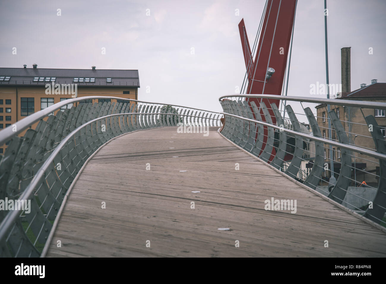 wooden and composite material foot bridge over water in green summer ...