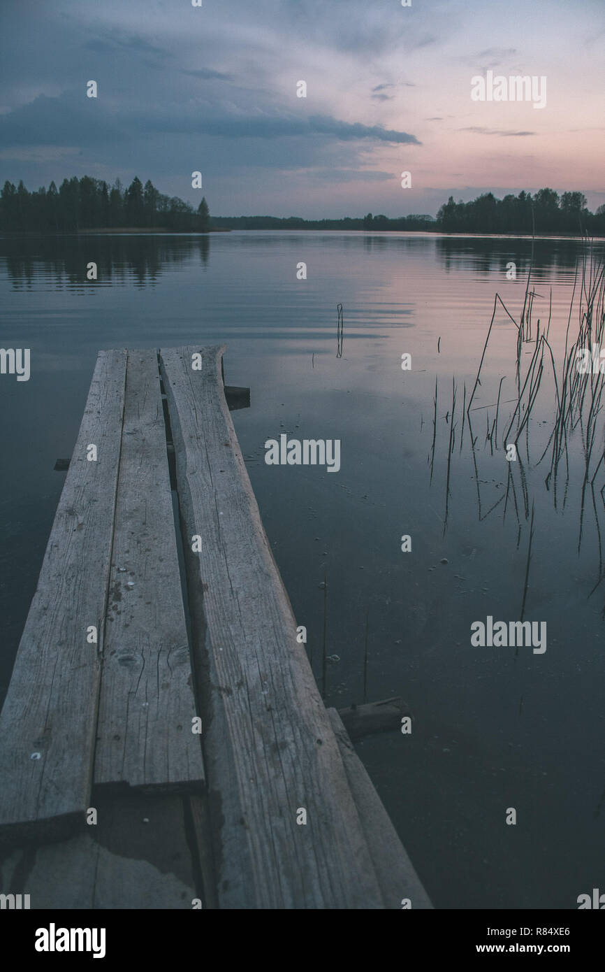 wooden and composite material foot bridge over water in green summer ...