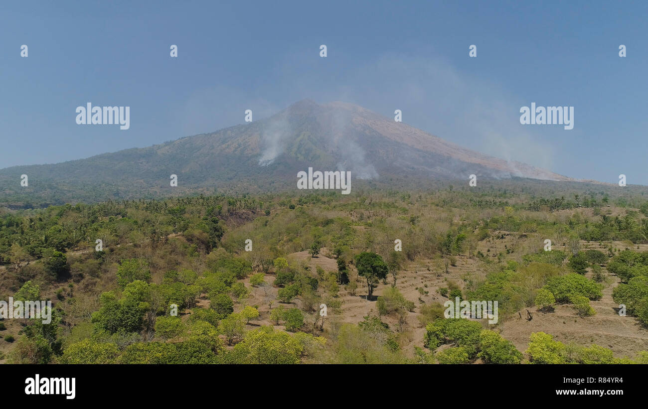 slopes volcano with forest fire, farmland at foot of the volcano Agung ...