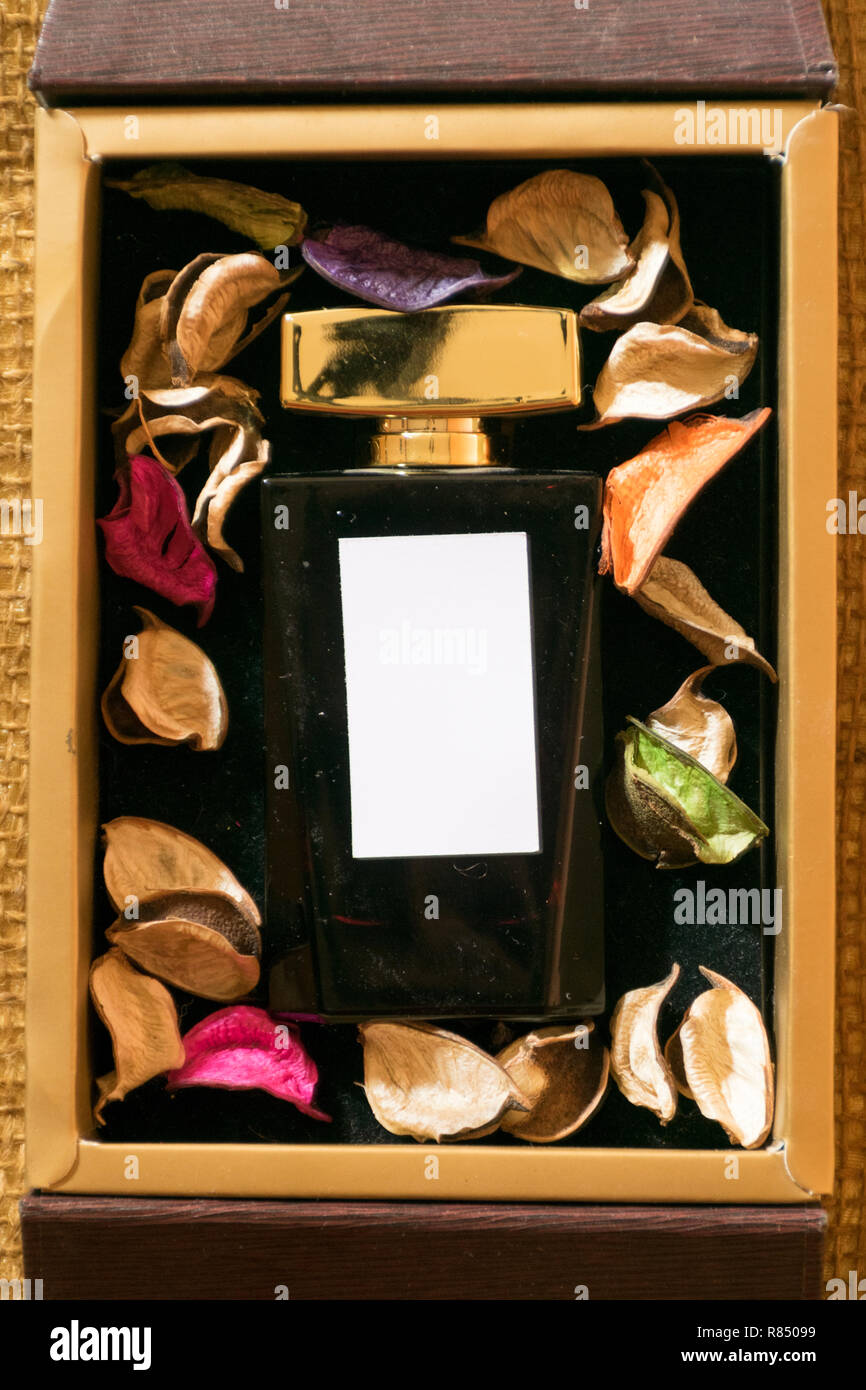 Perfume glass bottle inside golden gift box and colorful leaves with ...