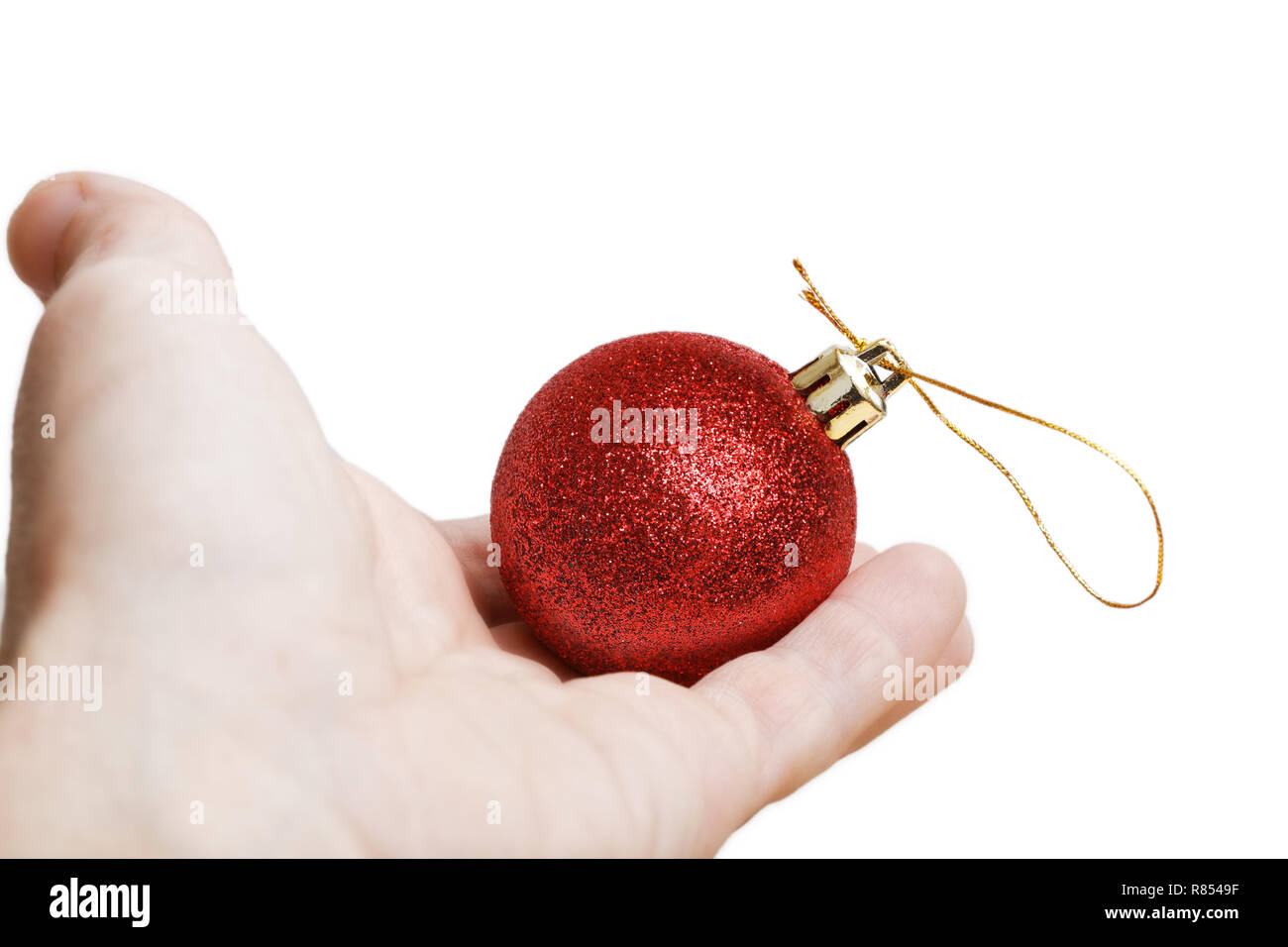 Christmas toy - red glitter new year ball in human hand isolated on ...
