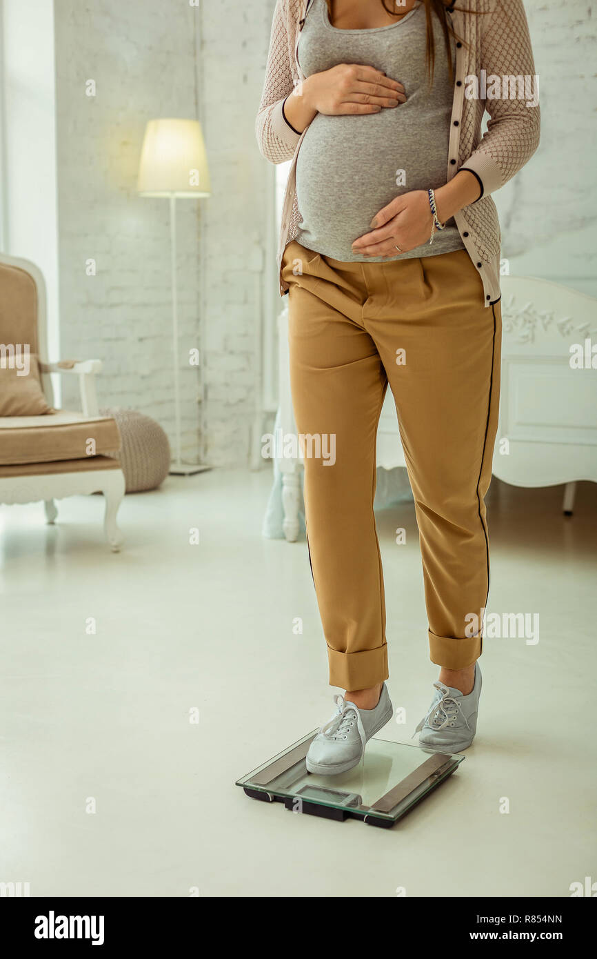 Tracking a weight. The pregnant woman controlling her weight by ...