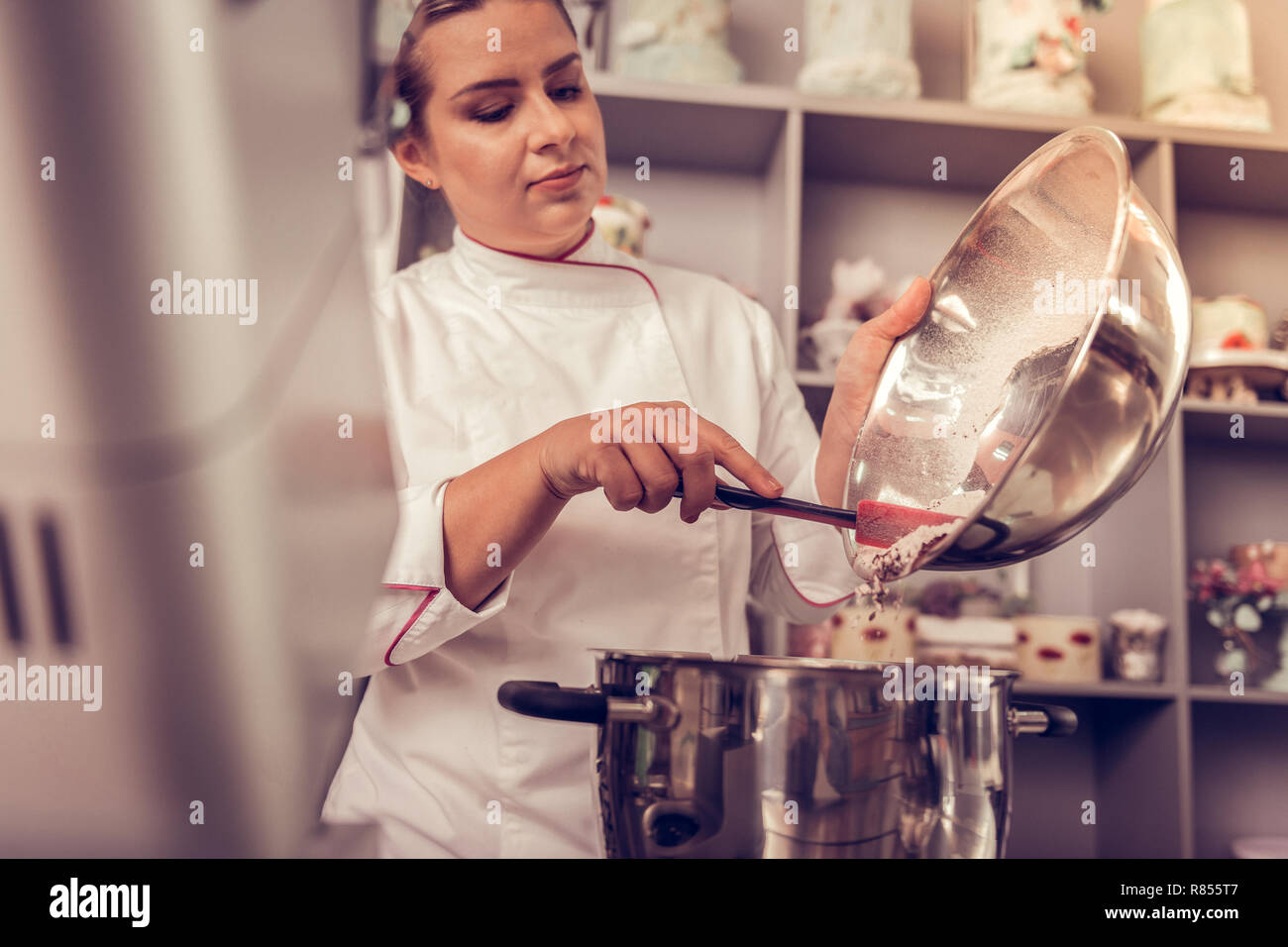 Mixture of ingredients. Close up of a bowl in female hands while being ...