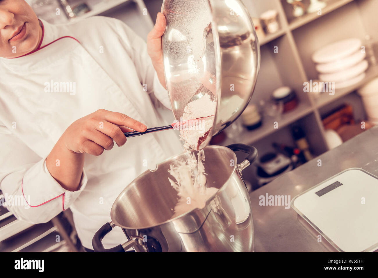 Special cake. Serious nice pastry chef looking into the bowl while ...