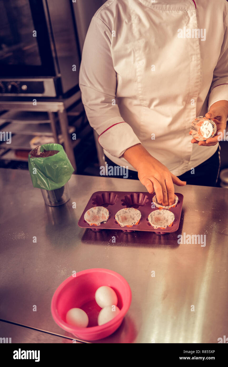 Muffin preparation. Top view of a muffin tray lying on the table during ...