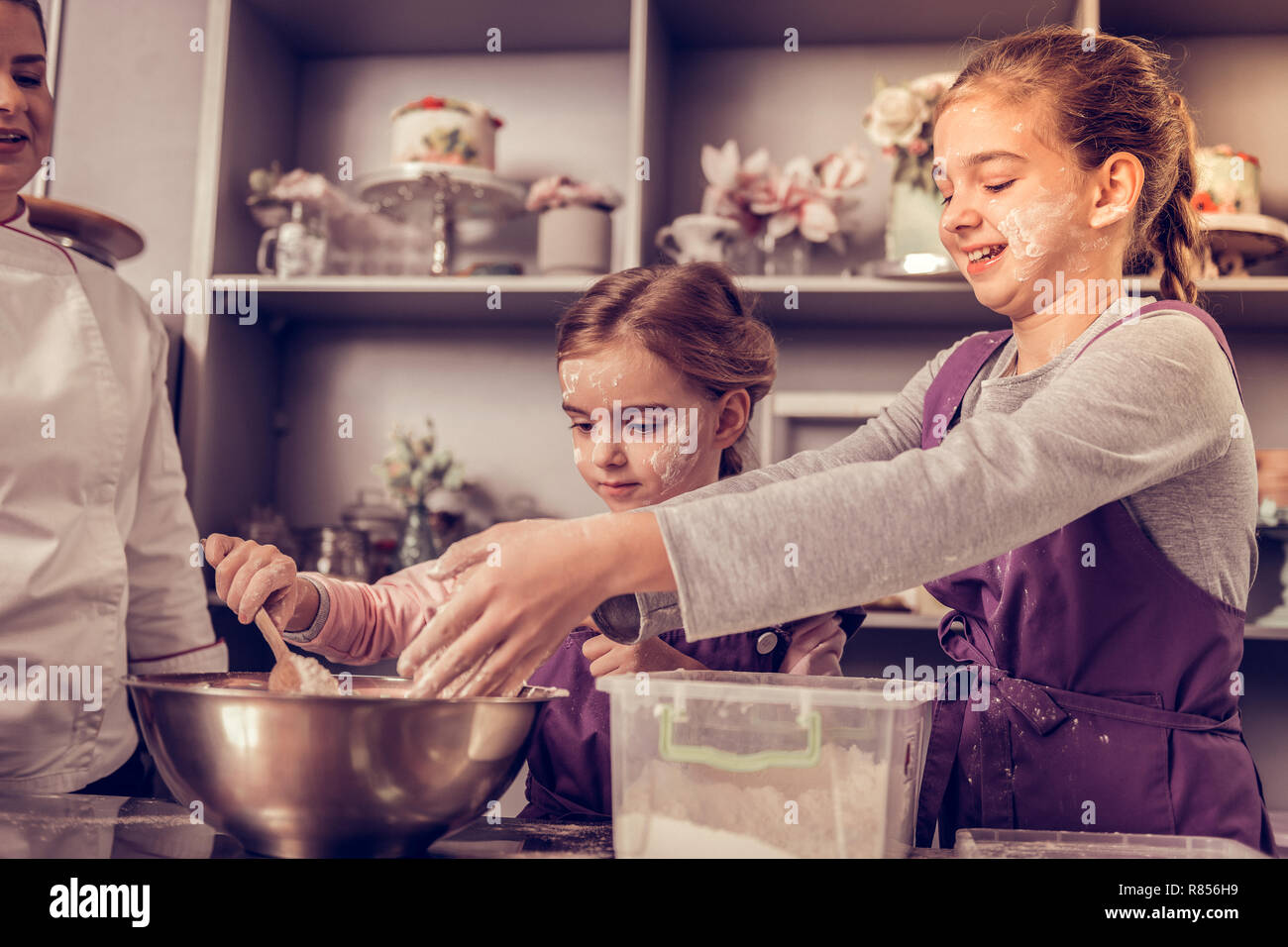 Family traditions. Nice happy sisters helping each other while cooking ...