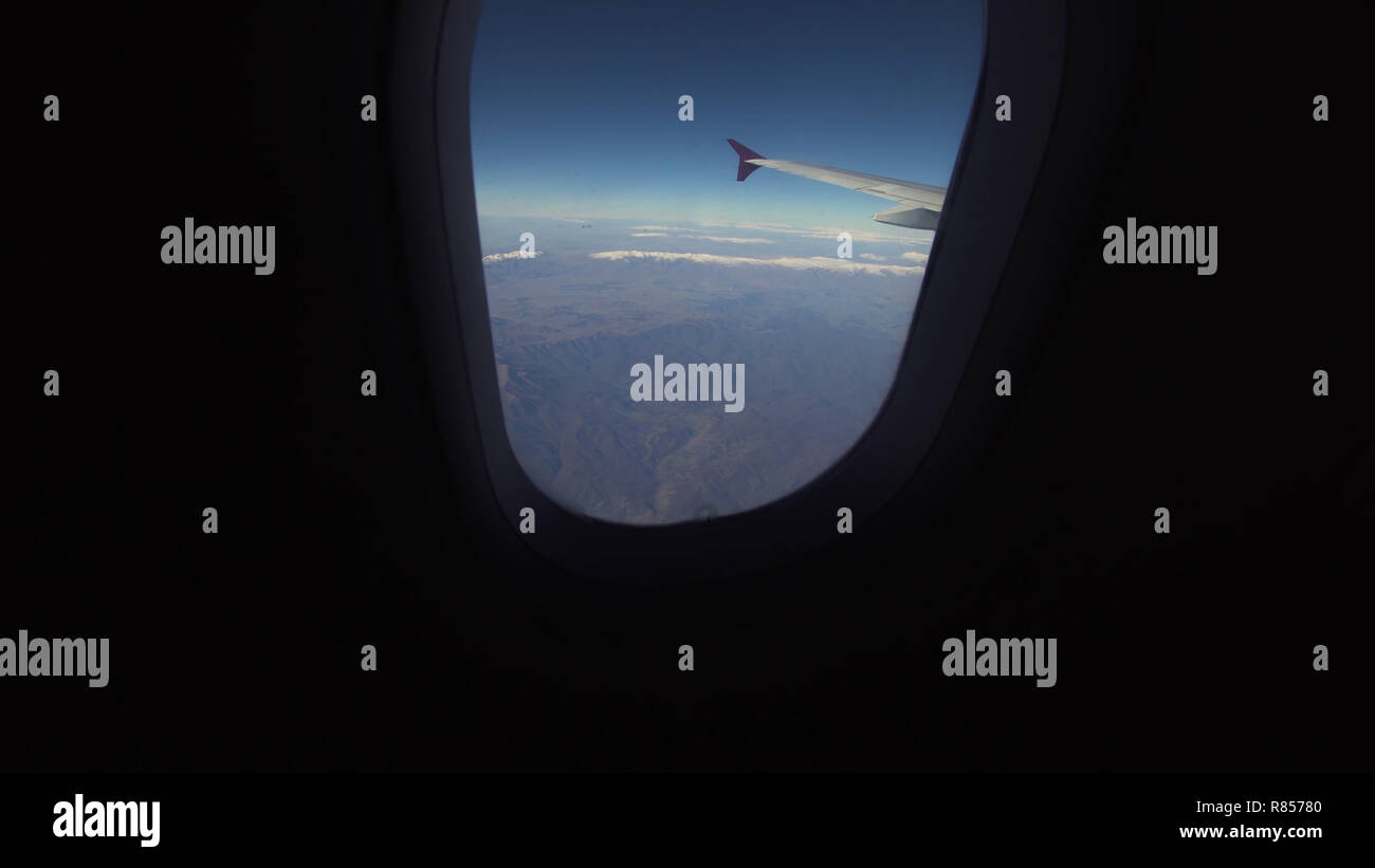 Mountain range from the airplane window. Airplane wing. Aerial view on ...