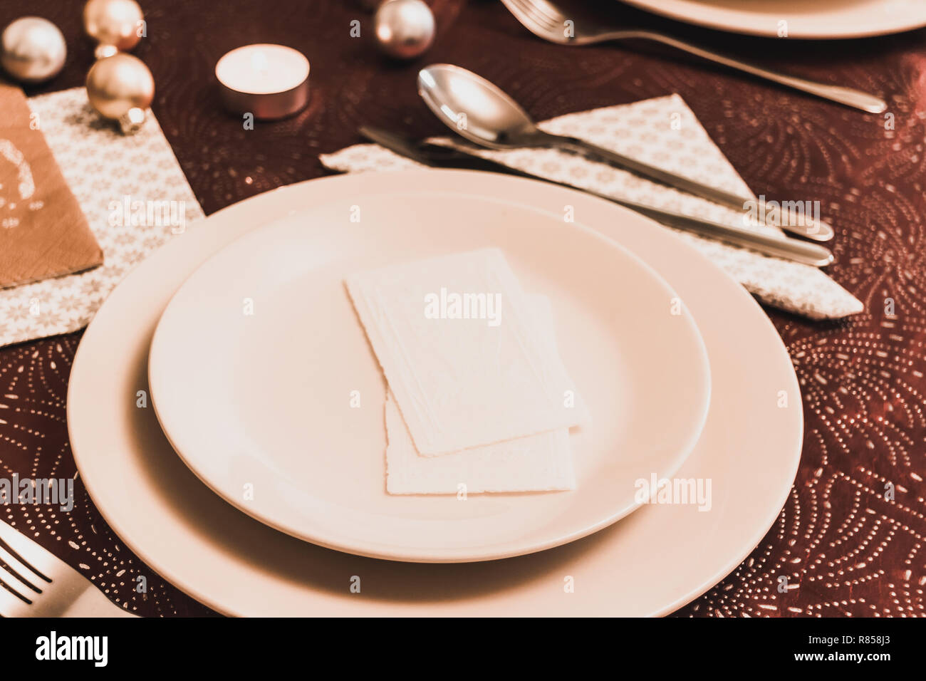 Monochromatic picture of Christmas place setting with wafer on plate ...