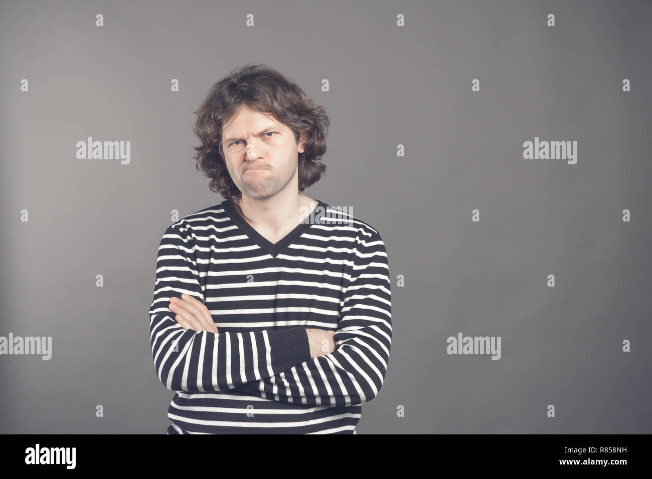 Closeup portrait of displeased, angry, grumpy man in striped sweater ...