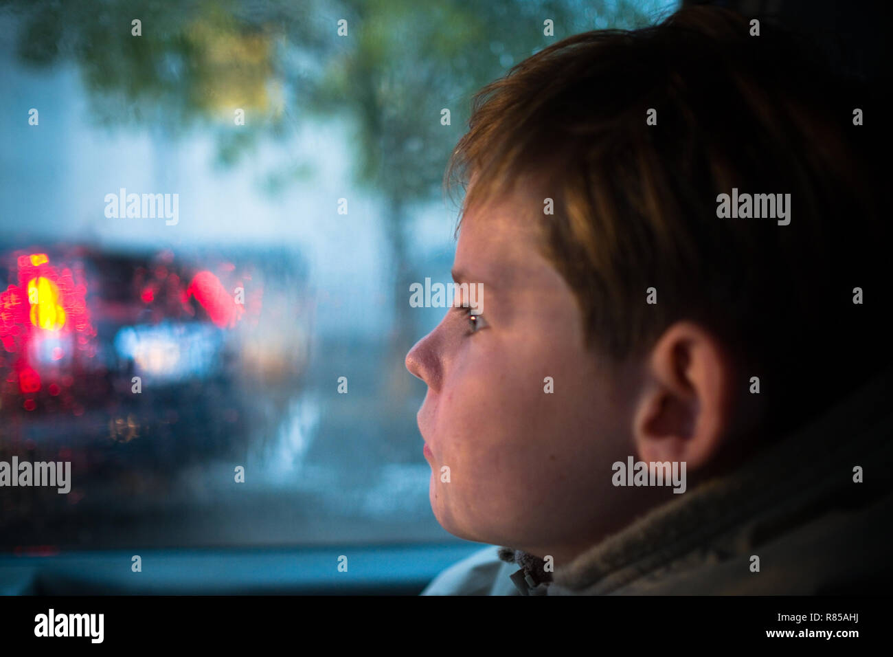 close up side profile of 11 year old boy inside car on way to school ...