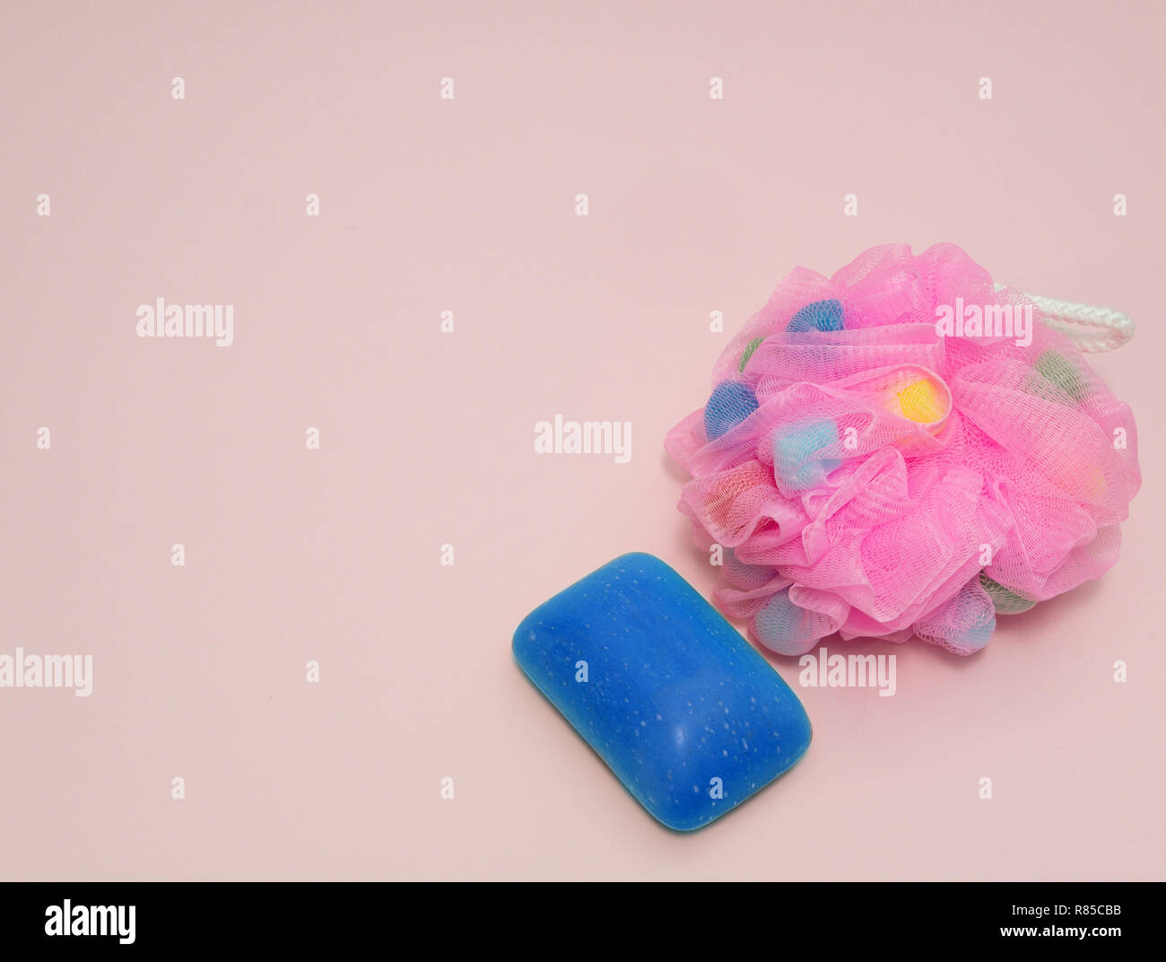 womans fancy bath sponge with blue sea salt soap on pink background ...