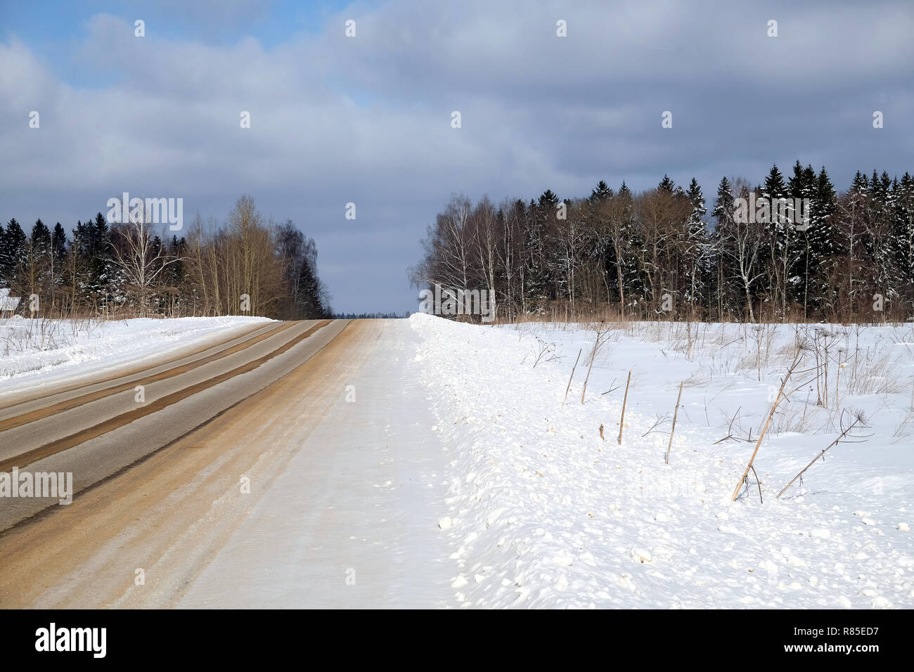 Beautiful winter landscape. Purified empty suburban sand-strewn road ...