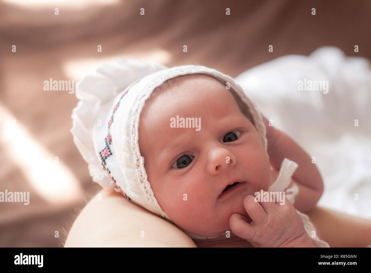 Portrait of cute caucasian newborn baby in white hat. Little baby lying ...