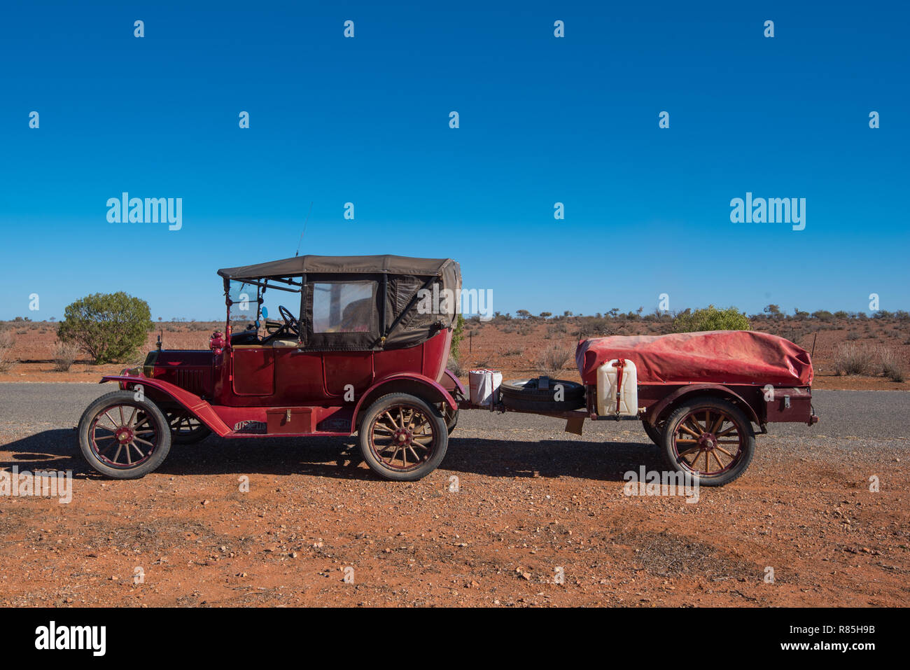 Vintage Model T Ford and vintage camper trailer travel through outback ...