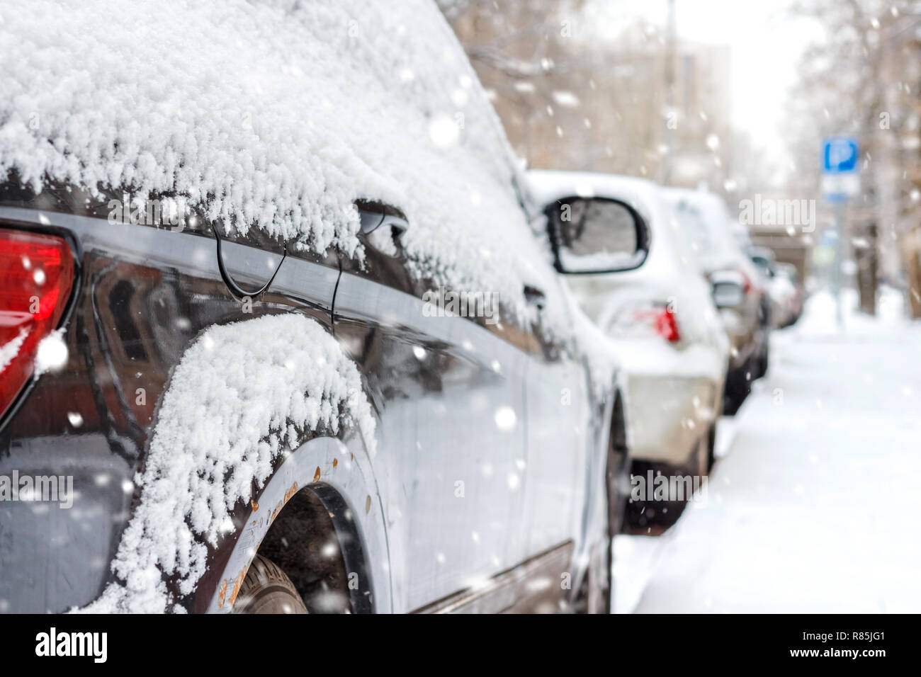 Snow-covered cars on parking in winter. Side view Stock Photo - Alamy