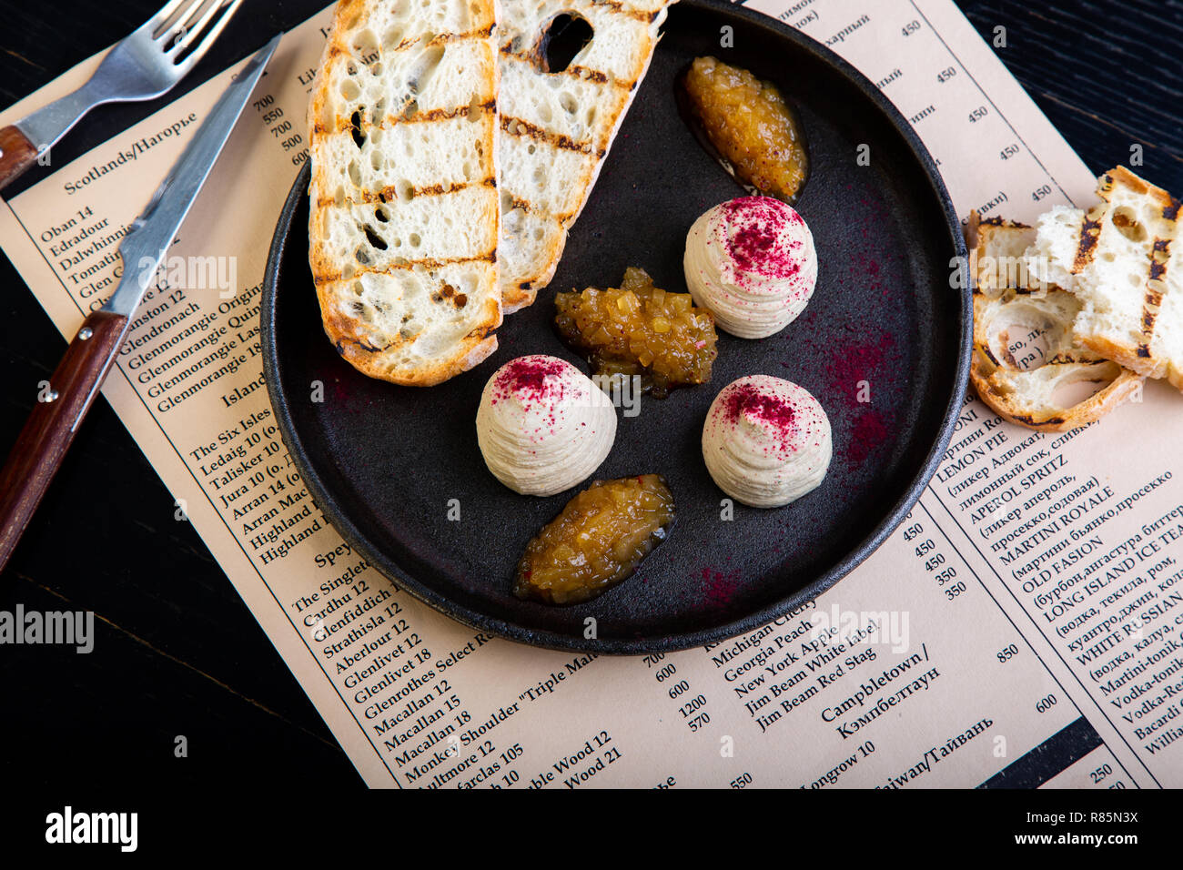 Restaurant dish background. Delicious pate on big black platter closeup ...