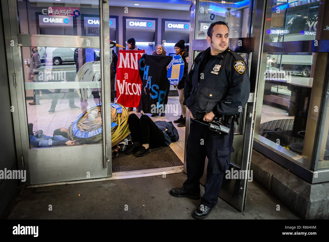 A police officer tries to keep the flow of foot traffic into the bank ...