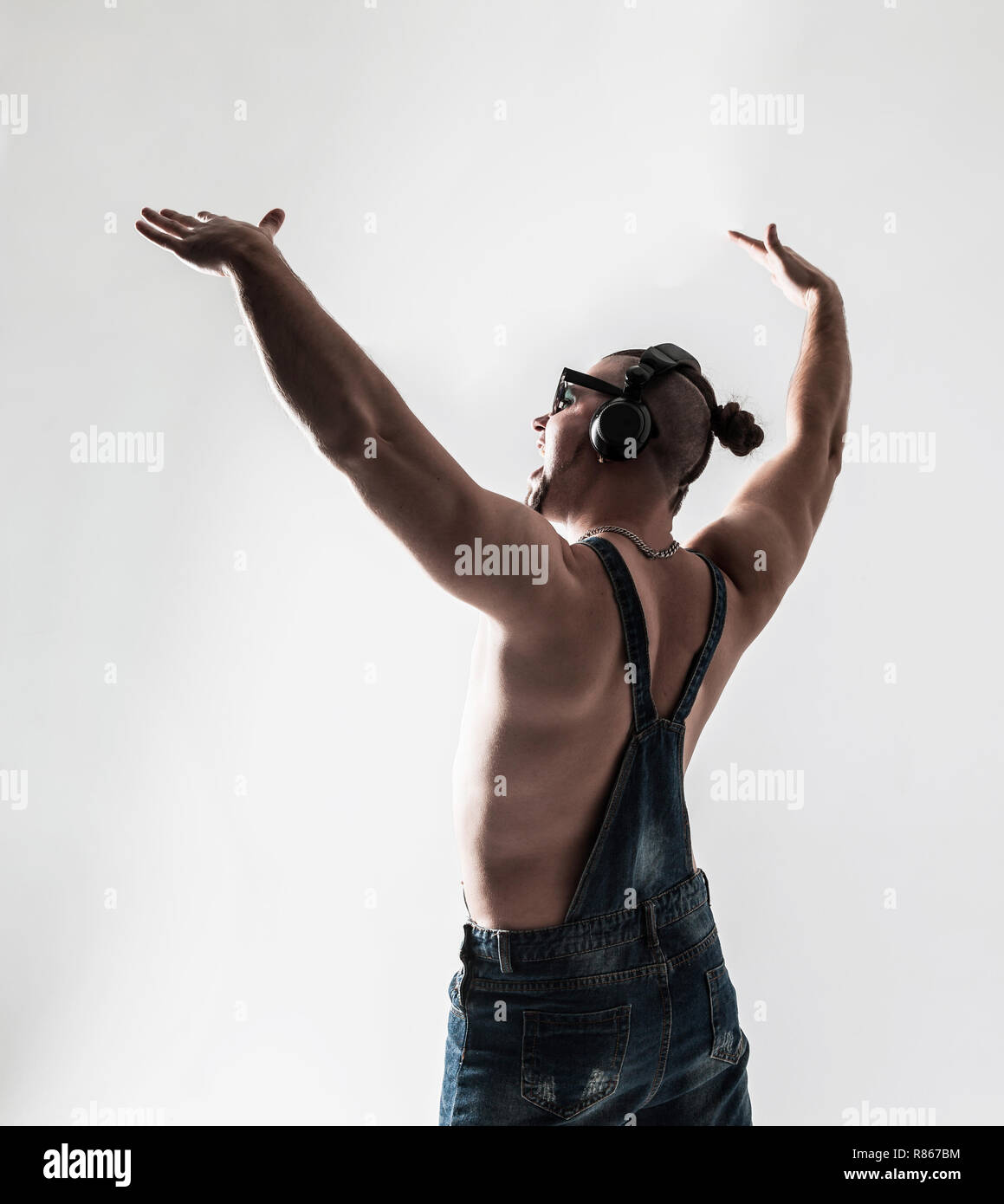 rear view - the rapper shirtless with headphones and stylish hai Stock ...