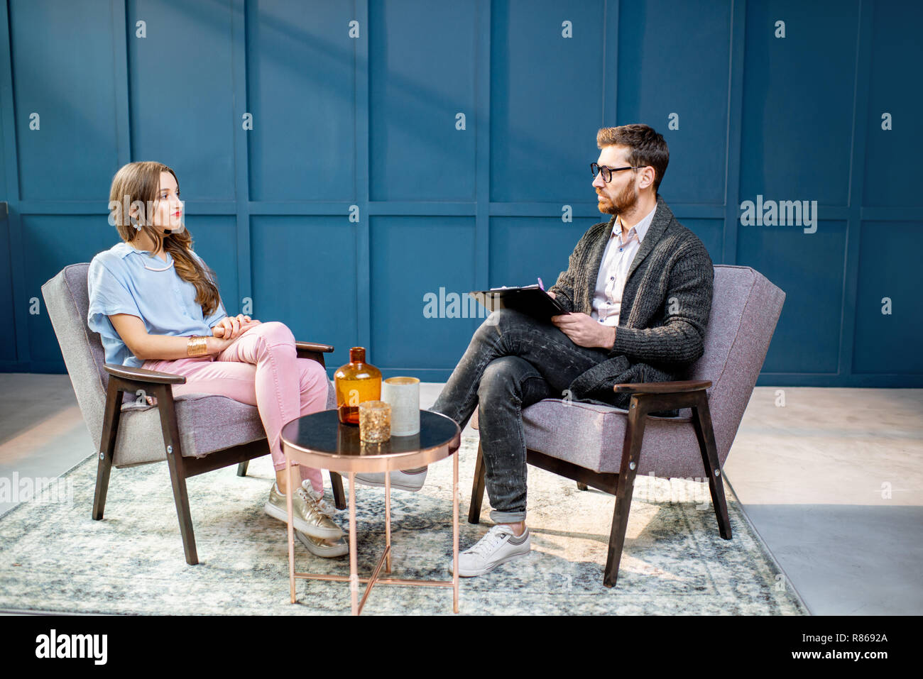 Woman client sitting with male psychologist on the chairs during the ...