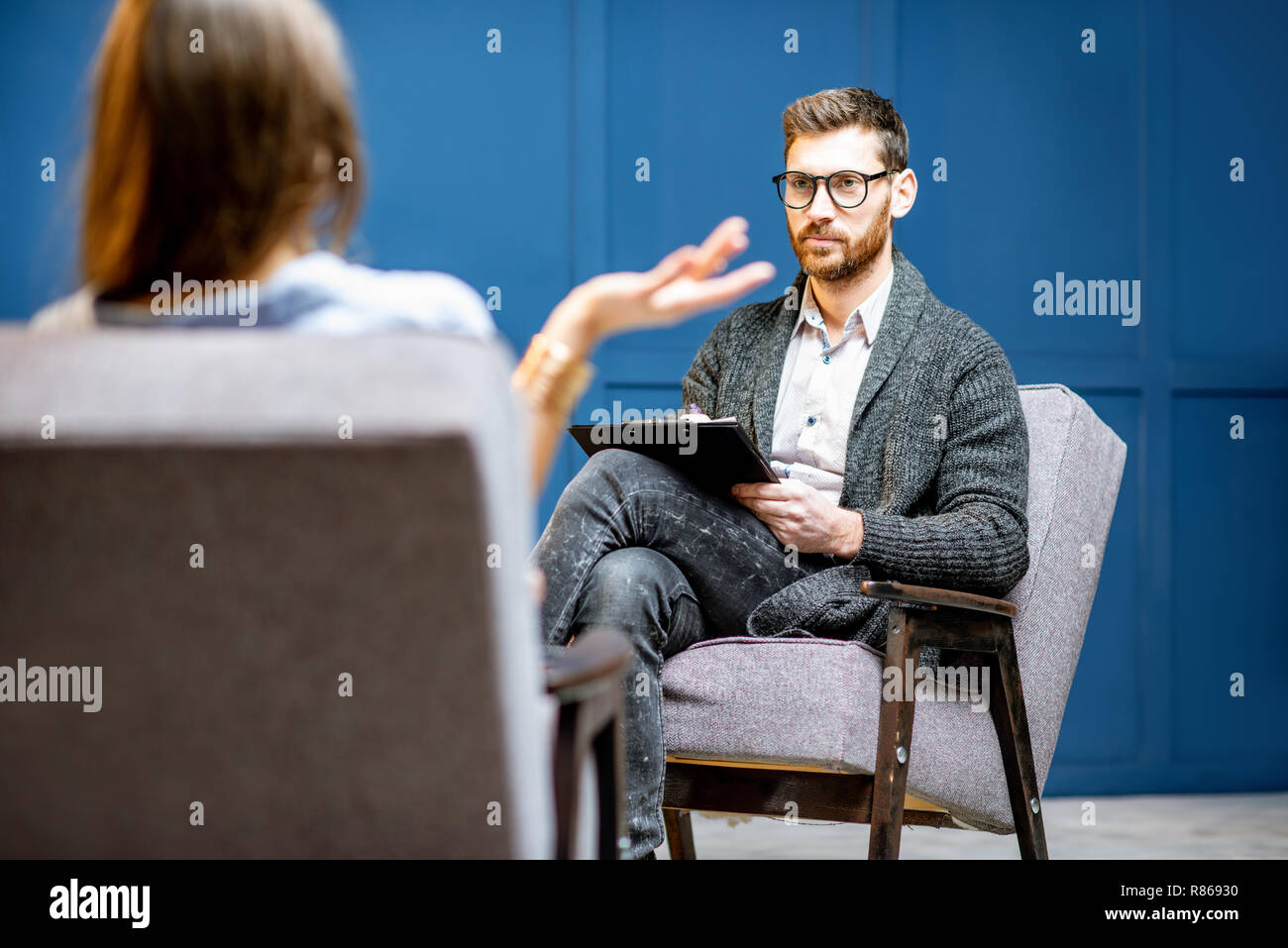 Handsome male psychologist listening to the woman client sitting during ...