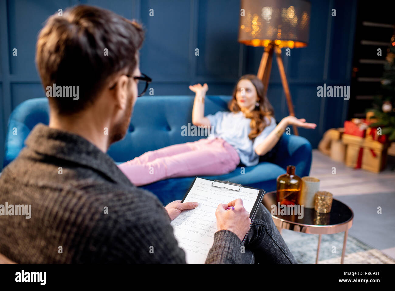 Psychologist writing some notes while listening to the woman client ...