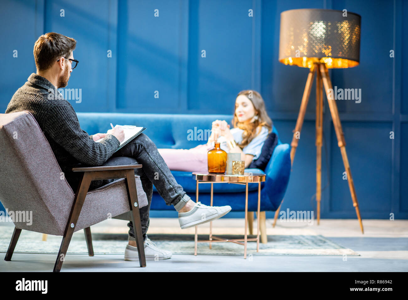 Young woman visiting male psychologist lying on the comfortable couch ...
