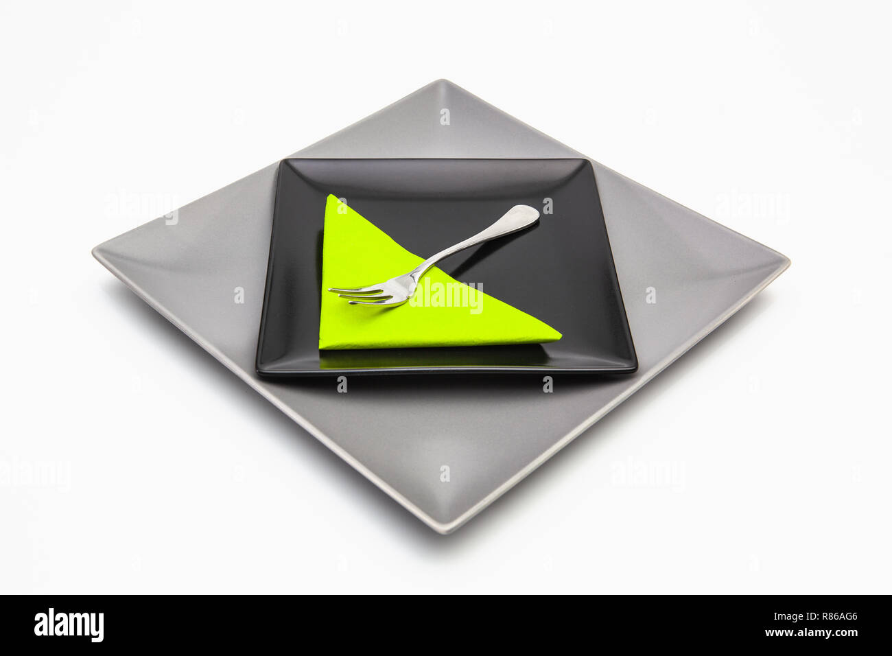 Black and gray square plates on the white wooden table.Top view.Flat ...