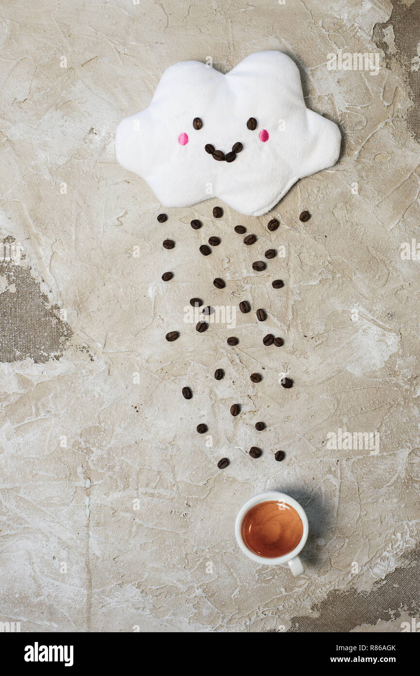 White cloud with happy face pouring rain of roasted beans into cup of ...