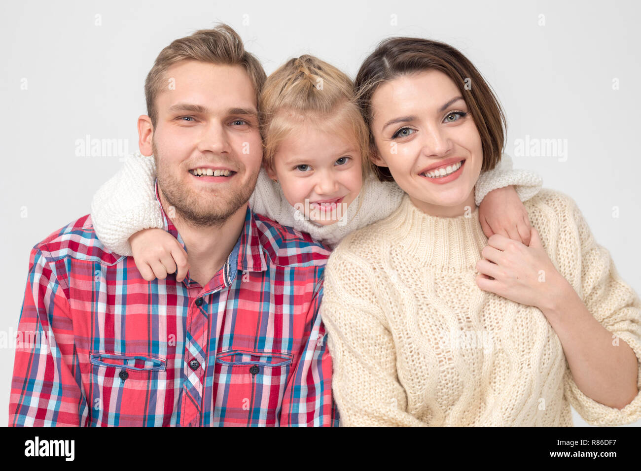 Happy family of three hugging on white background Stock Photo - Alamy