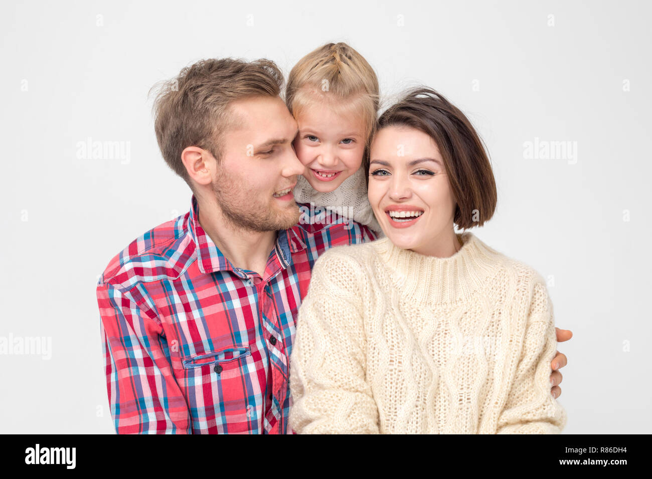 Happy family of three hugging on white background Stock Photo - Alamy