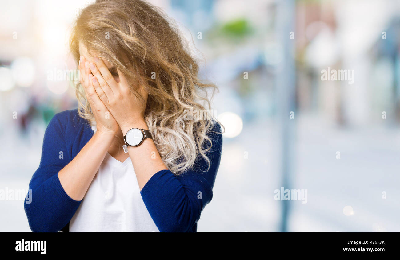 Beautiful young blonde woman over isolated background with sad ...