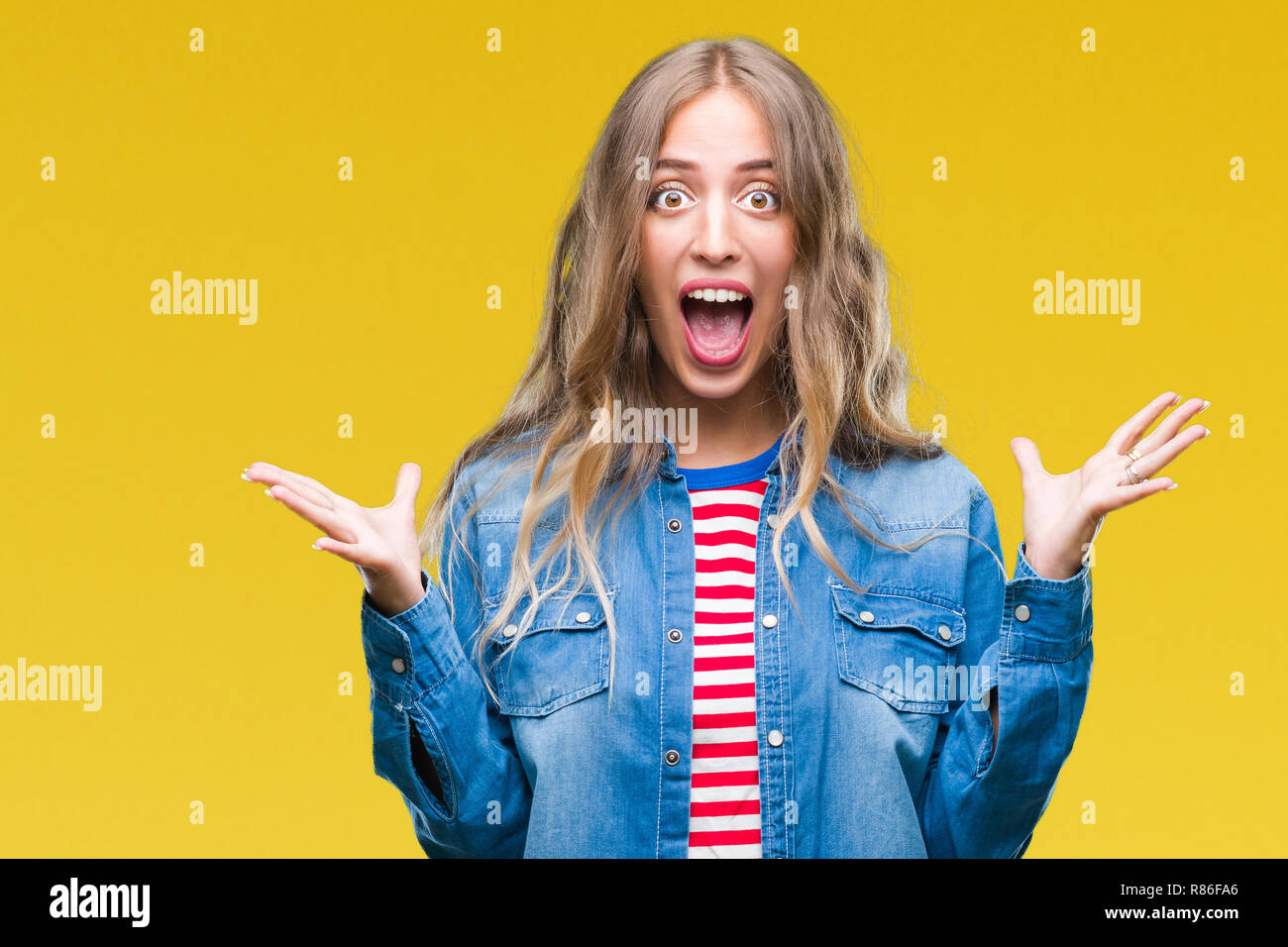 Beautiful young blonde woman over isolated background celebrating crazy ...