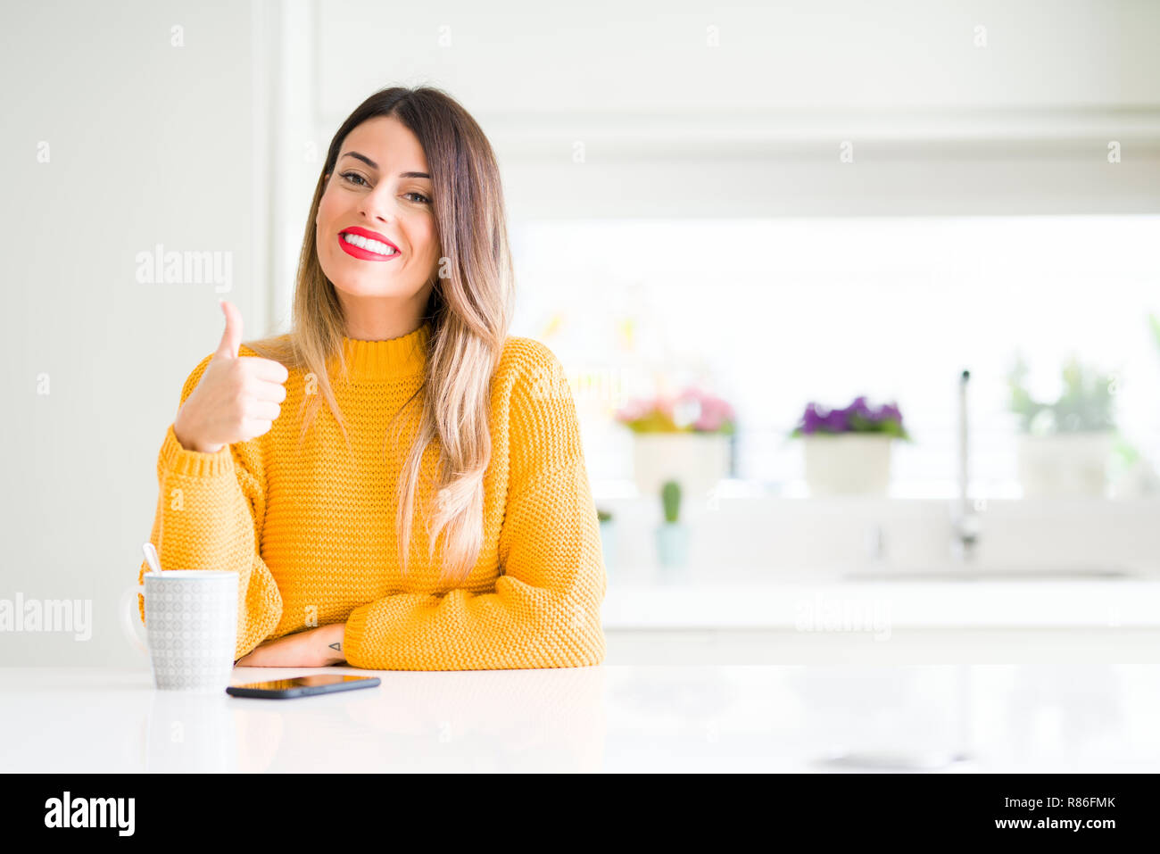 Young beautiful woman drinking a cup of coffee at home doing happy ...