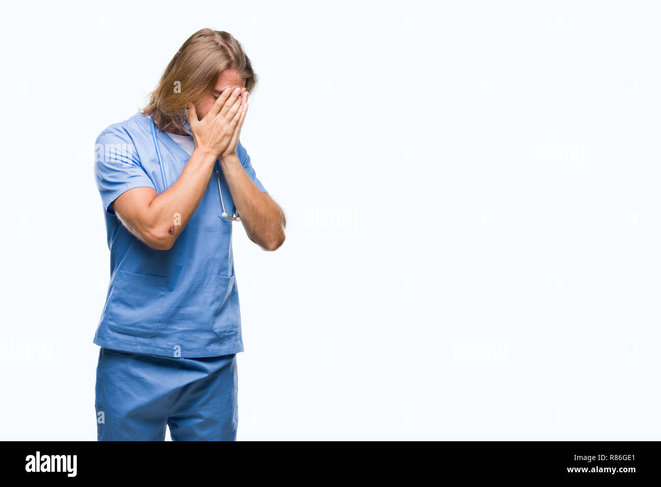 Young handsome doctor man with long hair over isolated background with ...