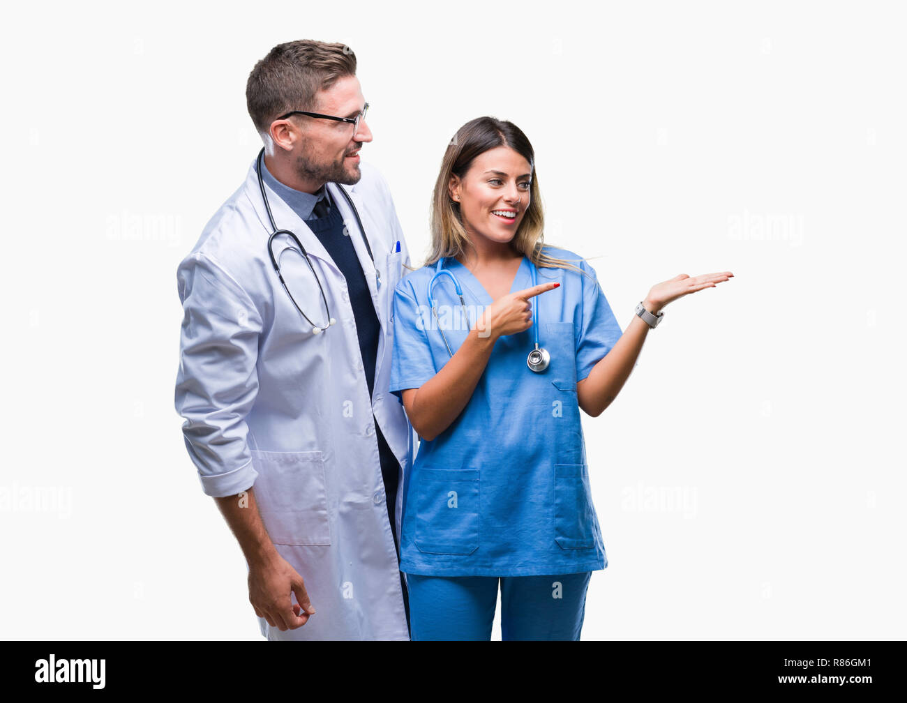 Young couple of doctor and surgeon over isolated background amazed and ...
