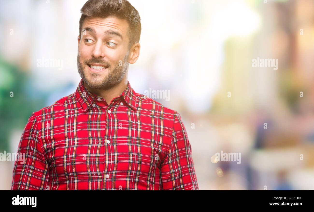 Young handsome man over isolated background smiling looking side and ...
