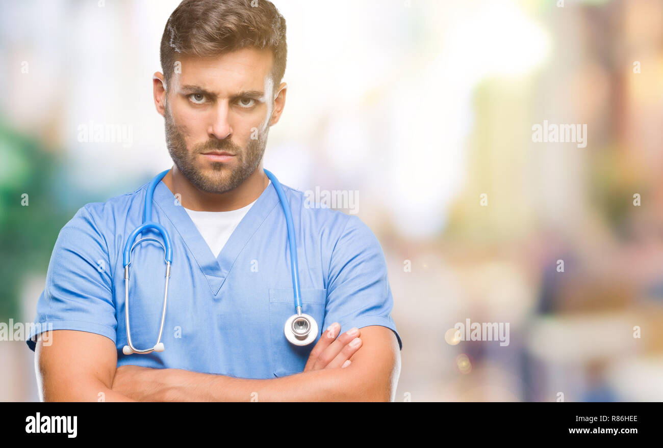 Young handsome doctor nurse man over isolated background skeptic and ...