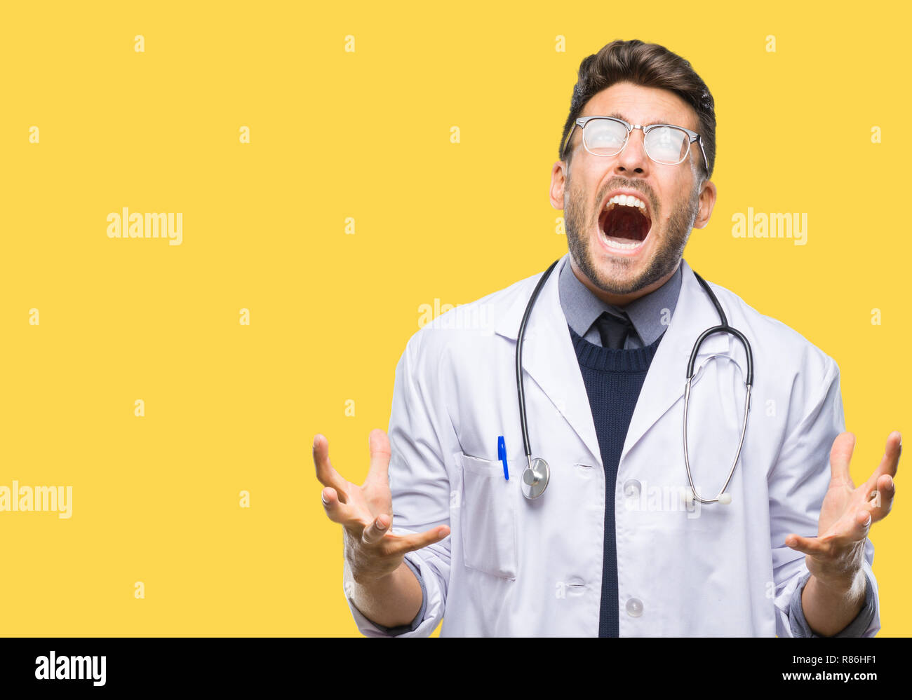 Young handsome doctor man over isolated background crazy and mad ...