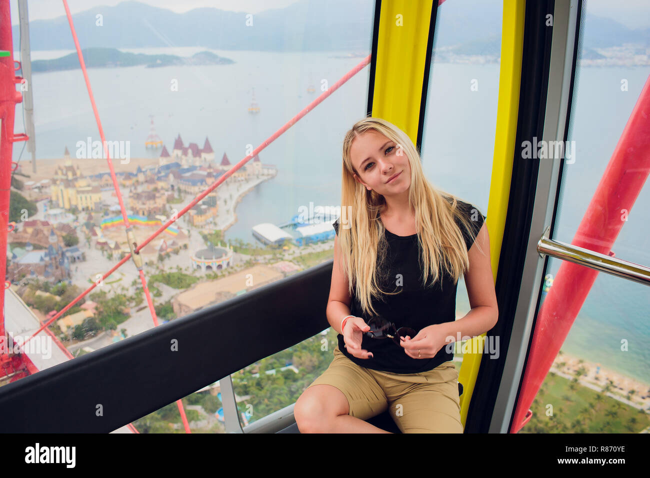 the girl sits in the booth of the Ferris wheel Stock Photo - Alamy