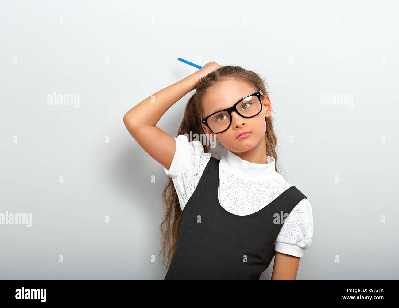 Thinking serious skeptical pupil girl in fashion eyeglasses in school ...