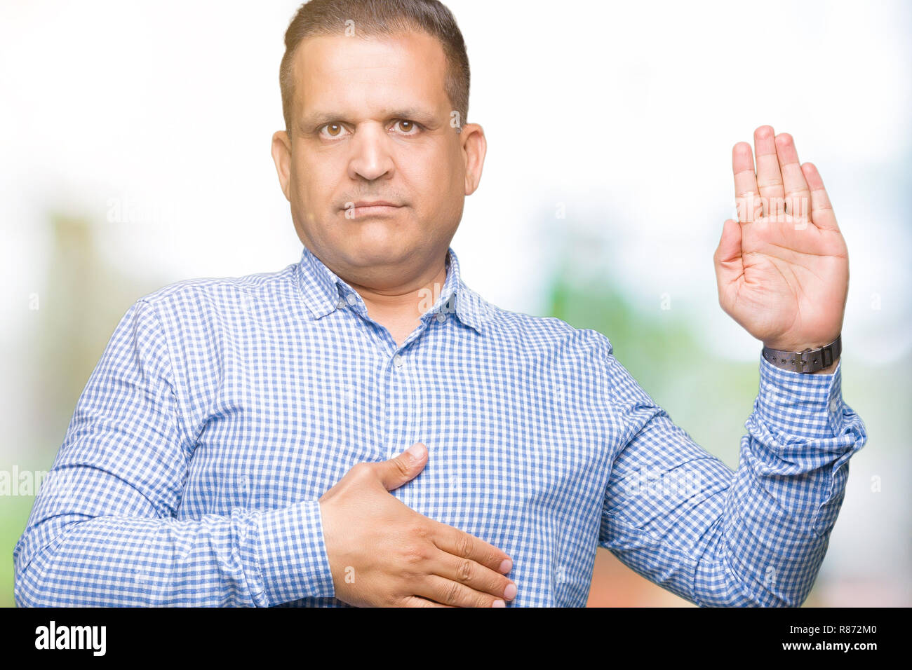 Middle age arab business man over isolated background Swearing with ...