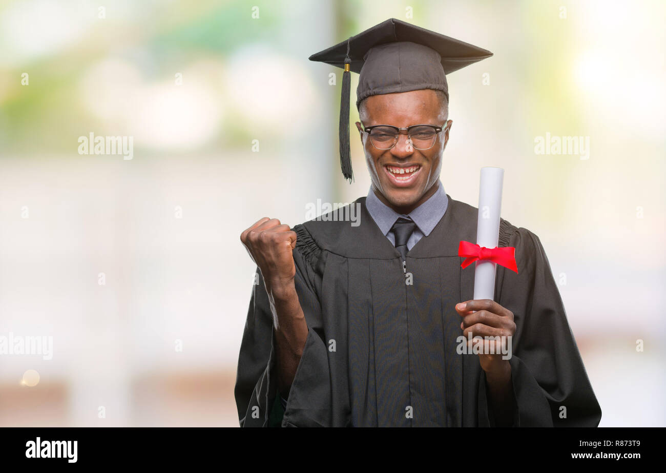 Young graduated african american man holding degree over isolated ...