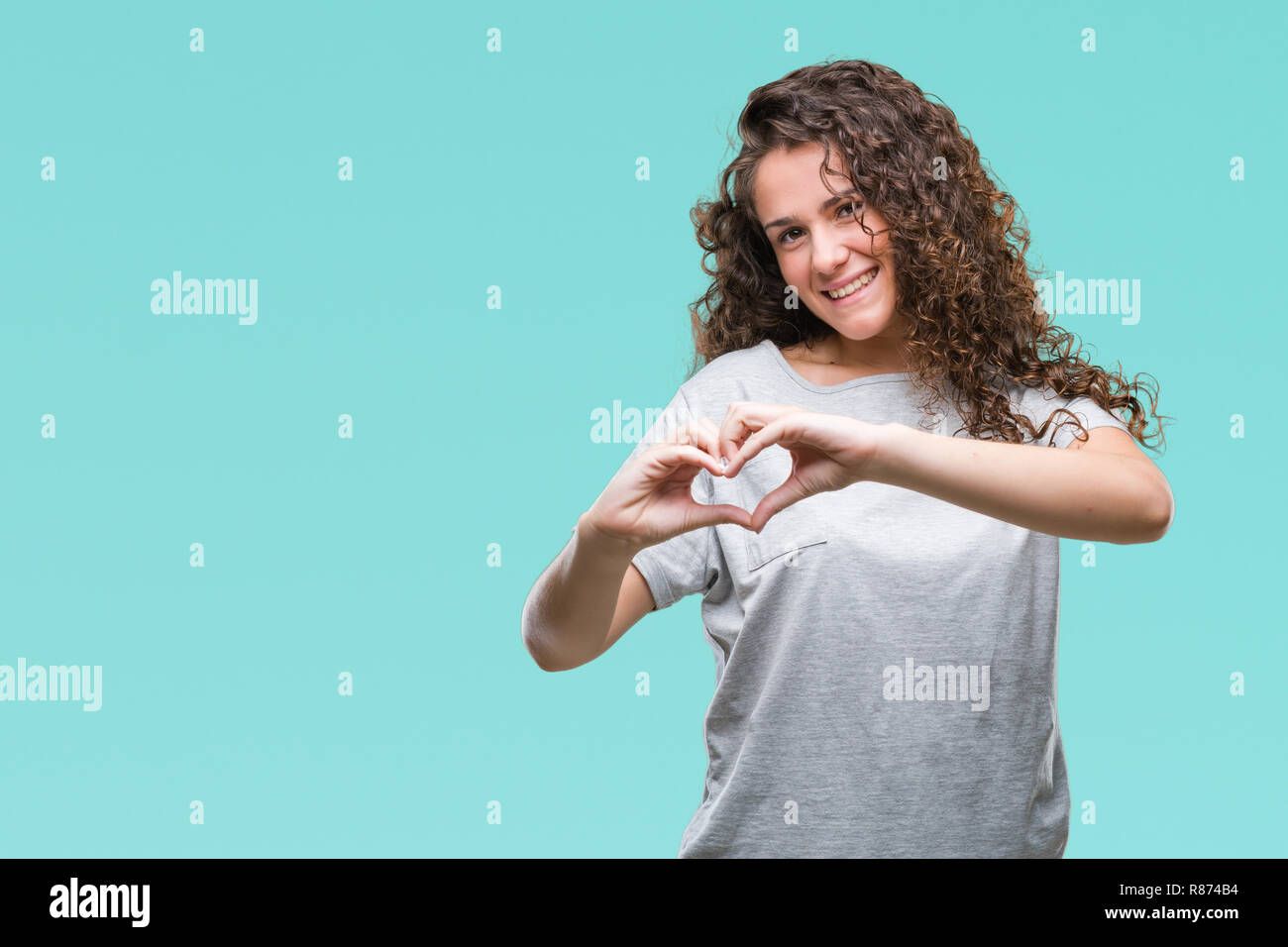 Beautiful young brunette curly hair girl wearing casual look over ...