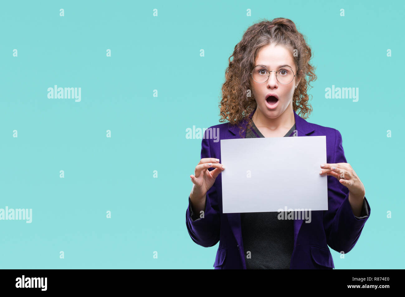 Young brunette student girl wearing school uniform holding blank paper ...