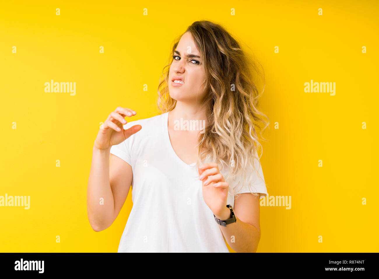 Young beautiful blonde woman over yellow background disgusted ...