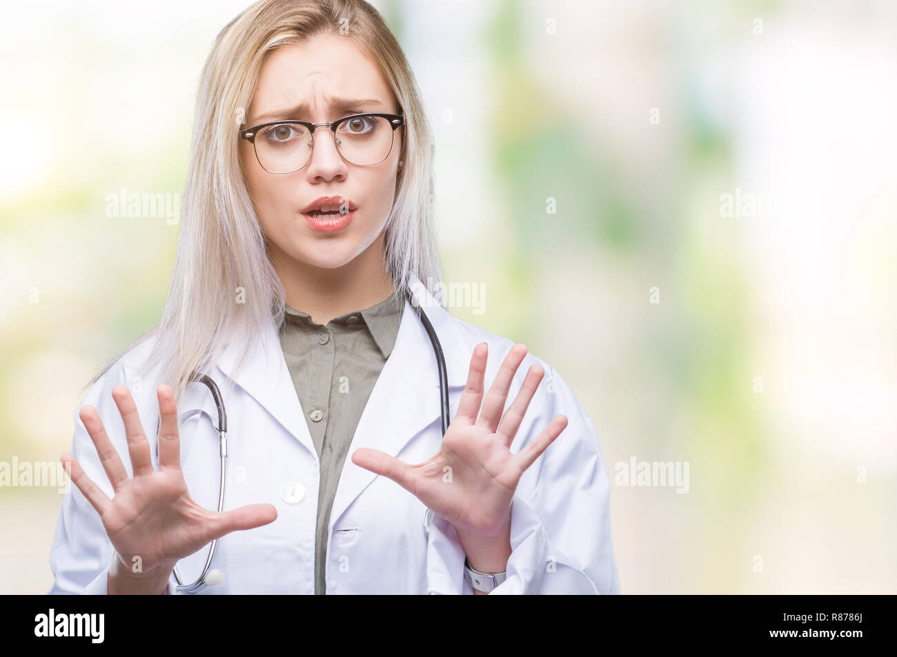 Young blonde doctor woman over isolated background afraid and terrified ...