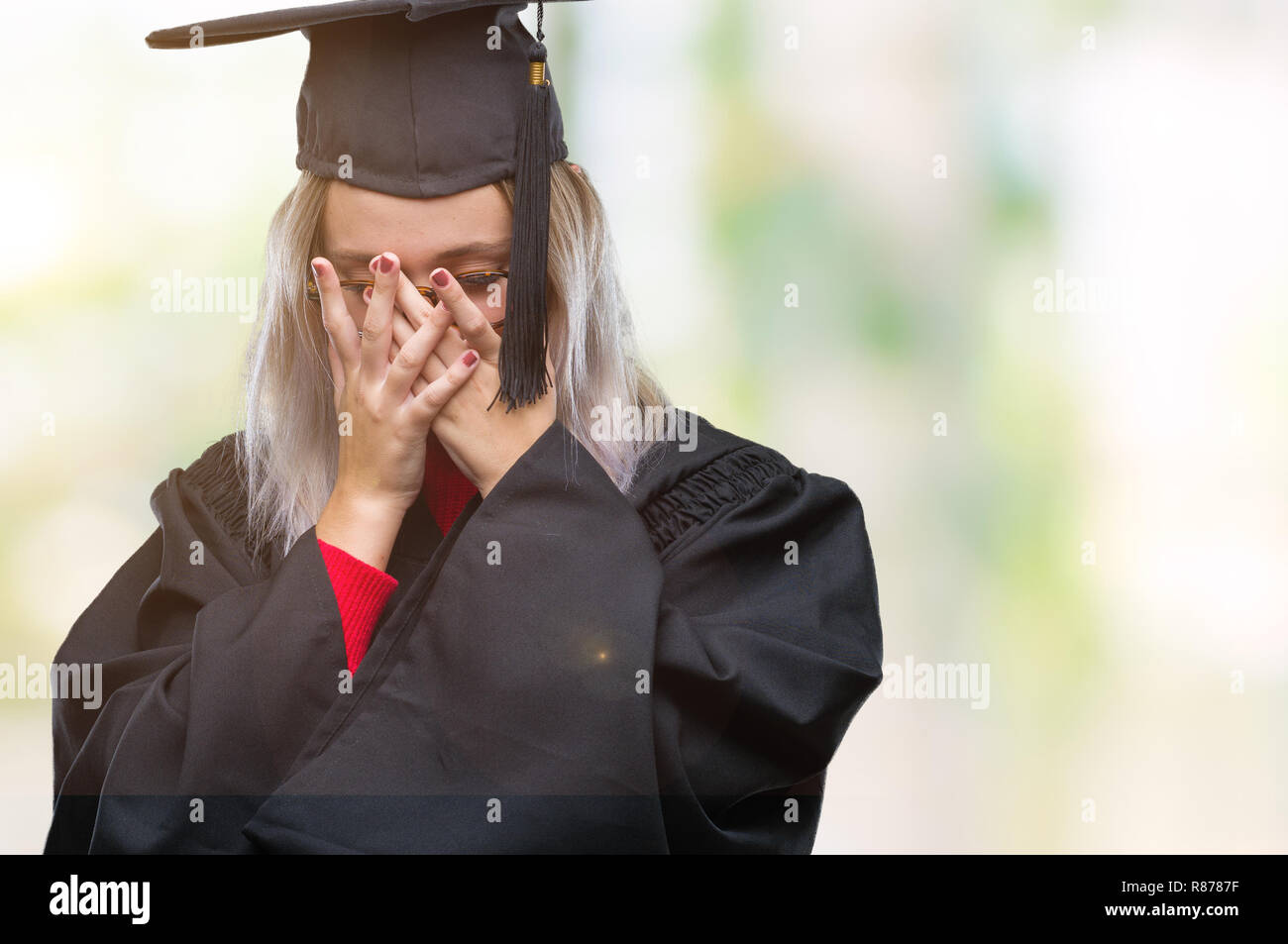 Young blonde woman wearing graduate uniform over isolated background ...